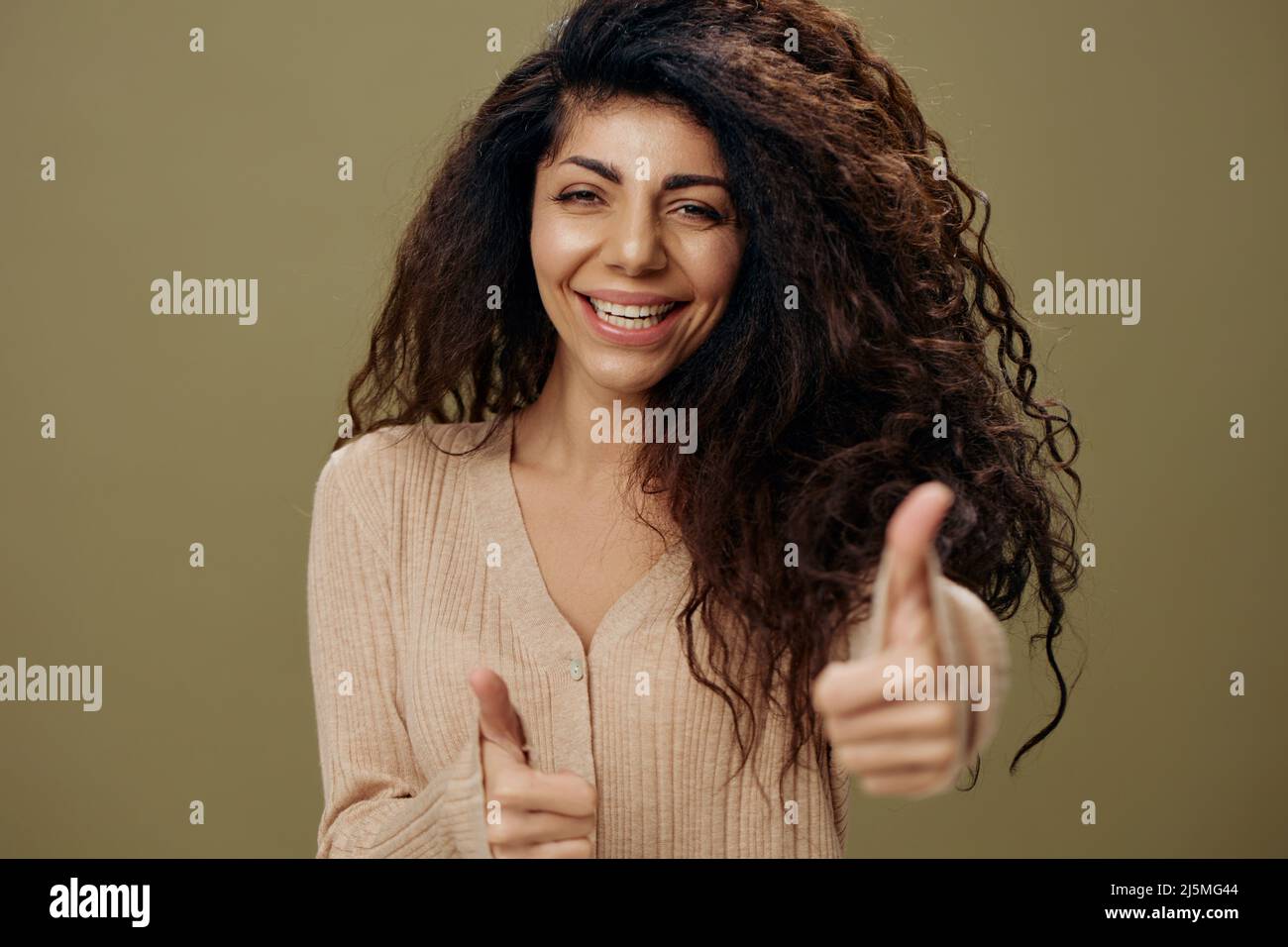 Happy enjoyed tanned curly Latin female in casual things show gesture ...