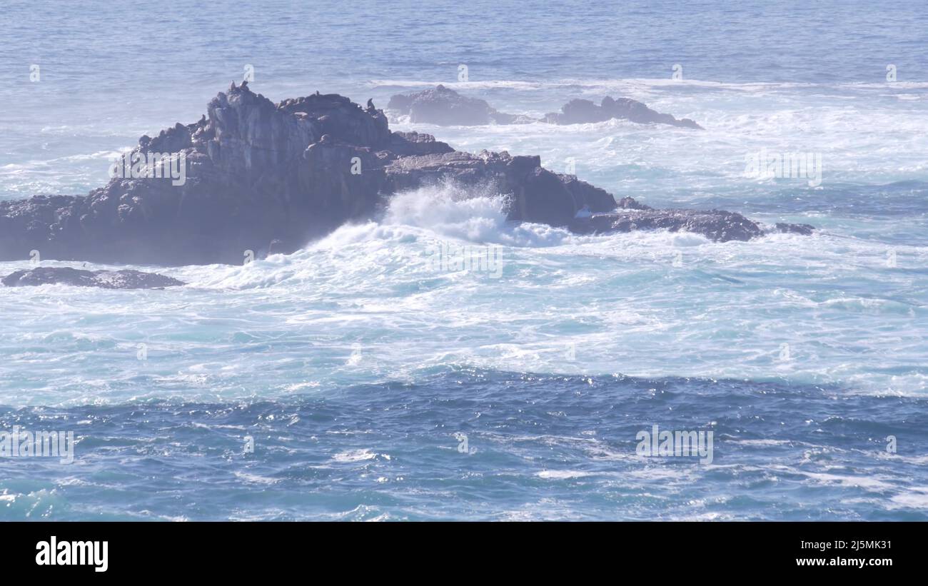 Rocky craggy dramatic ocean beach near Big Sur, 17-mile drive. Big blue ...