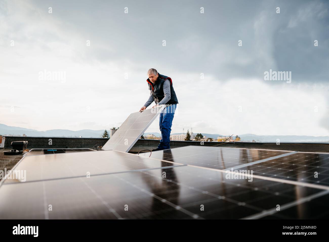 Man installing solar photovoltaic panel system. Technician working with ...