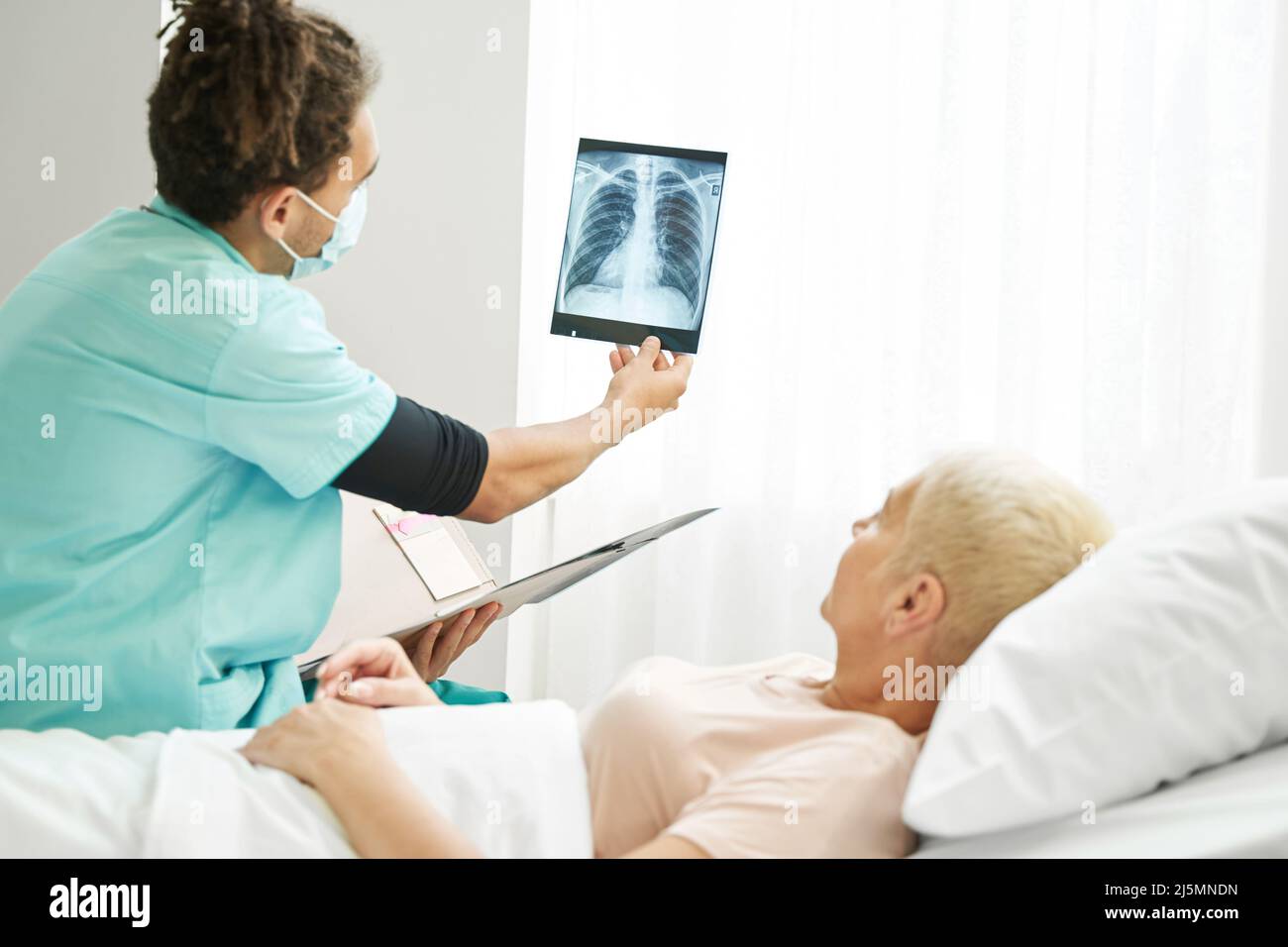 Doctor checking chest x-ray while sitting near patient Stock Photo - Alamy