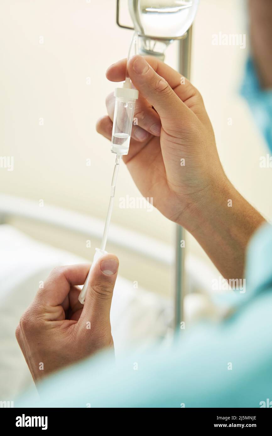 Medical professional controlling drip of IV line Stock Photo - Alamy