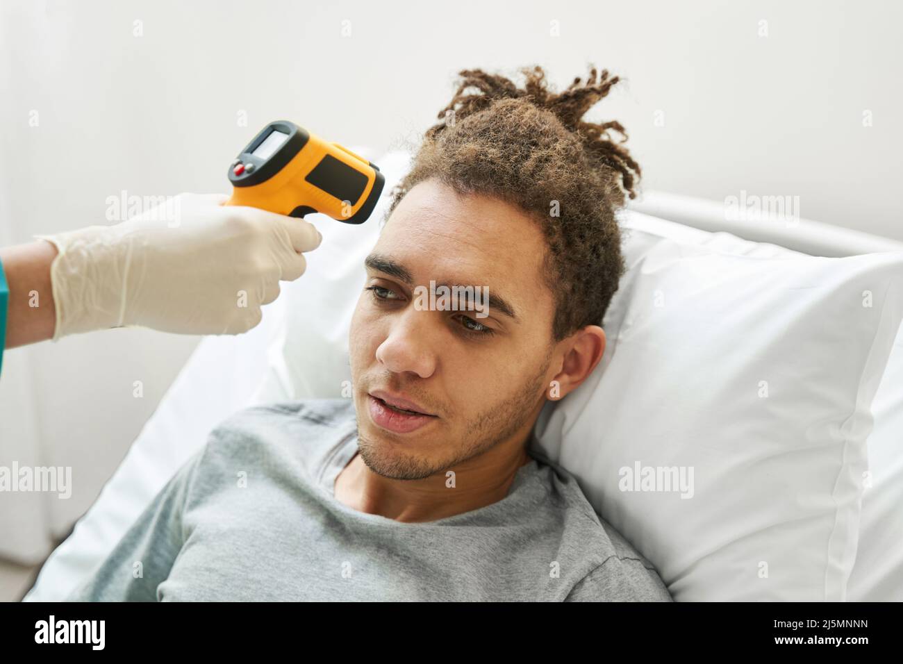 Person using temperature gun on man forehead Stock Photo - Alamy
