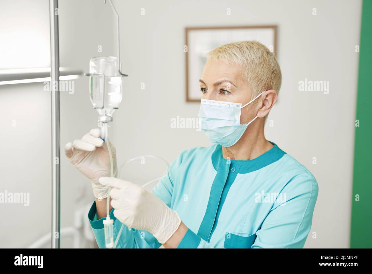 Doctor putting medical fluid into IV bottle Stock Photo - Alamy