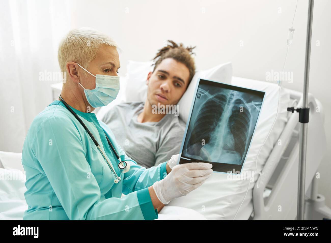 Aging female doctor explaining x-ray to man Stock Photo - Alamy