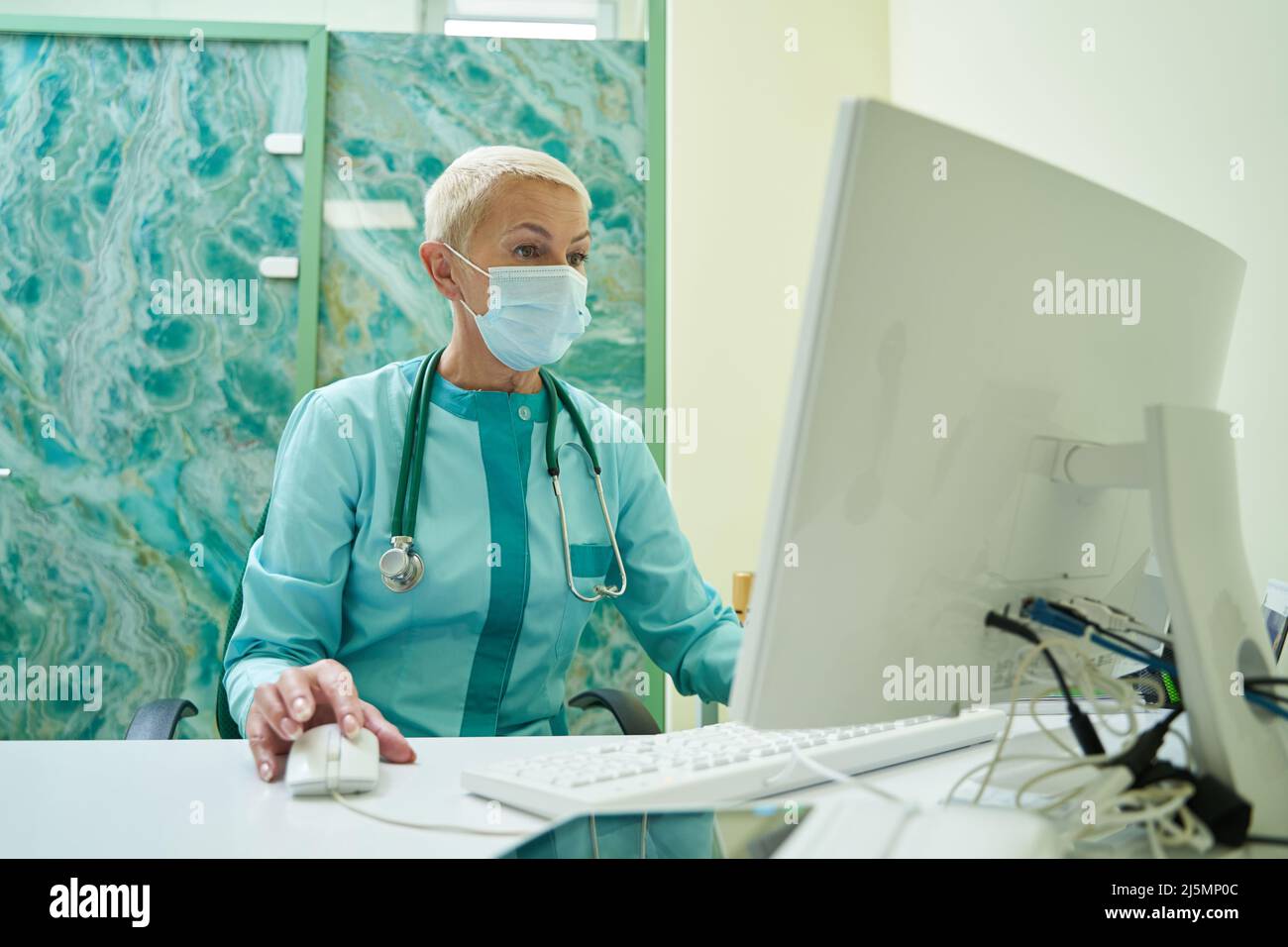 Female physician staring into computer screen during work Stock Photo ...
