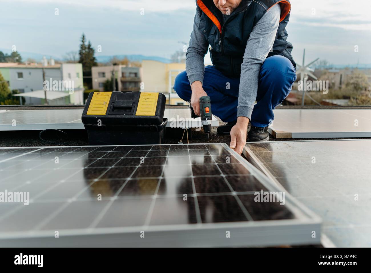 Engineer installing solar photovoltaic panel system using screwdriver ...