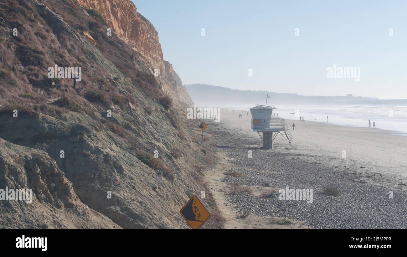 Steep cliff, rock or bluff, California coast erosion, Del Mar, San Diego, USA. People walking ...