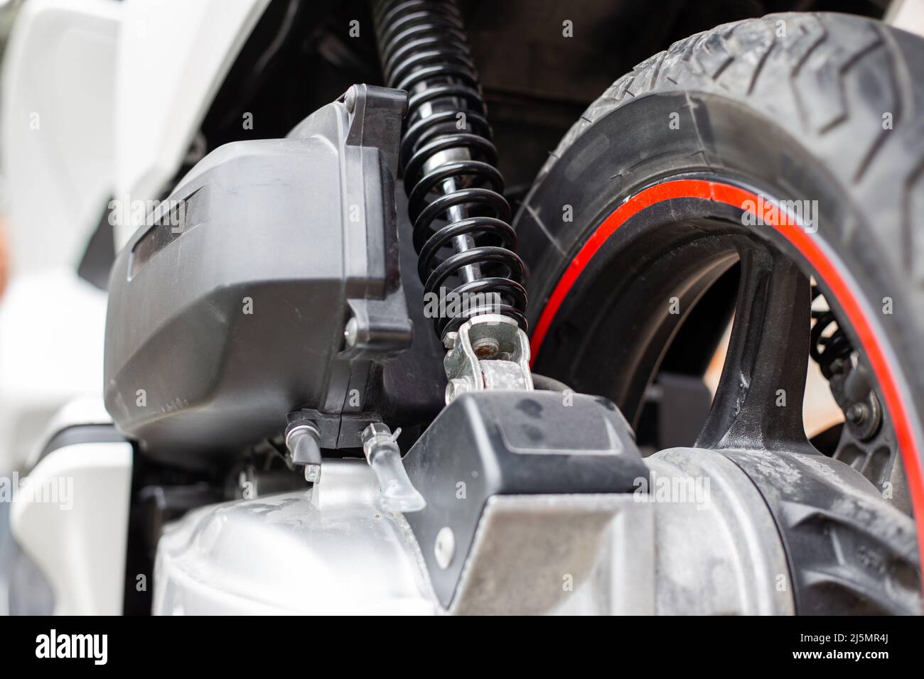 The rear wheel of a motorbike with a shock absorber spring and an air ...