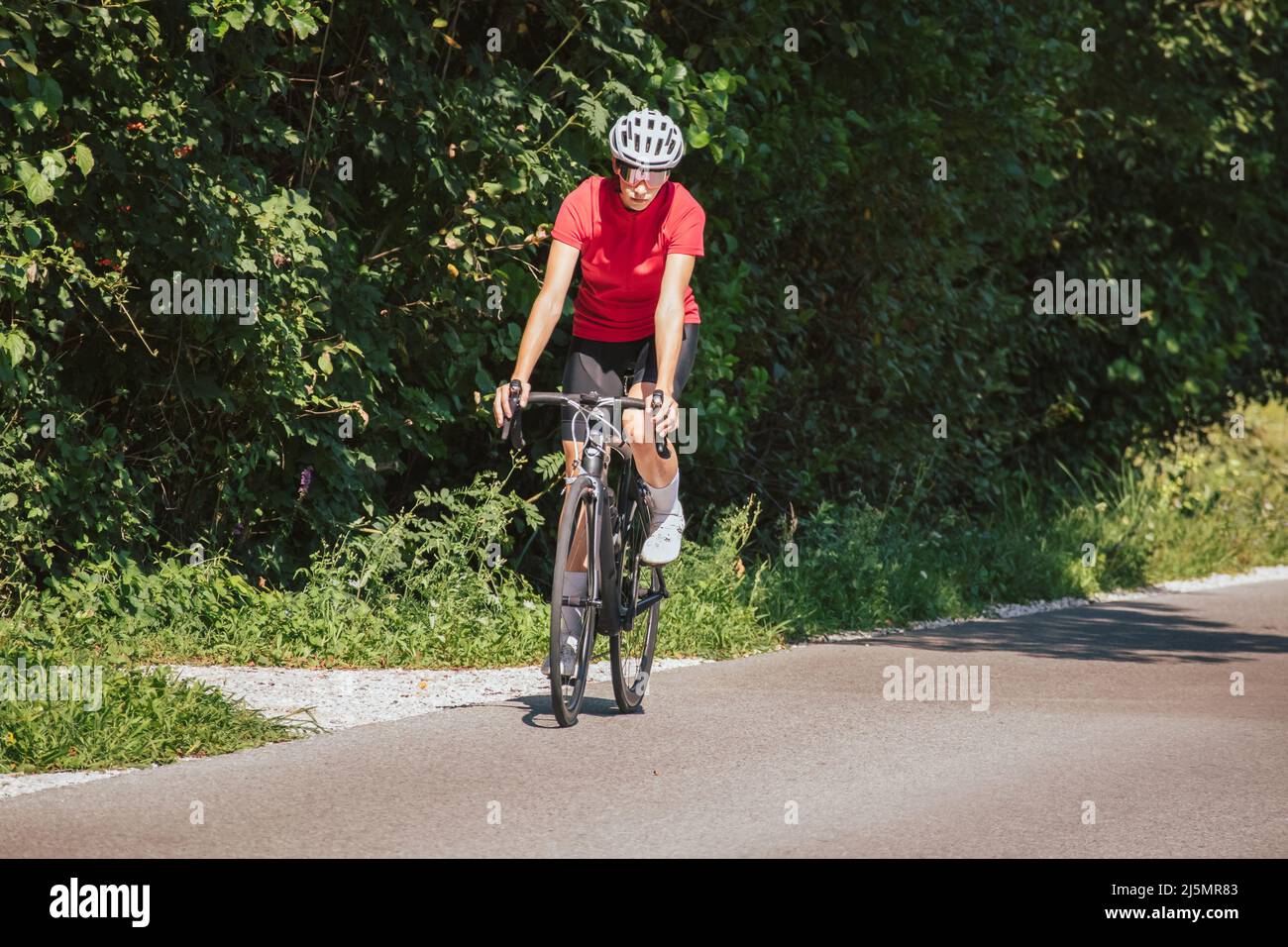 Young female professional bicyclist during road cycling sprint ...