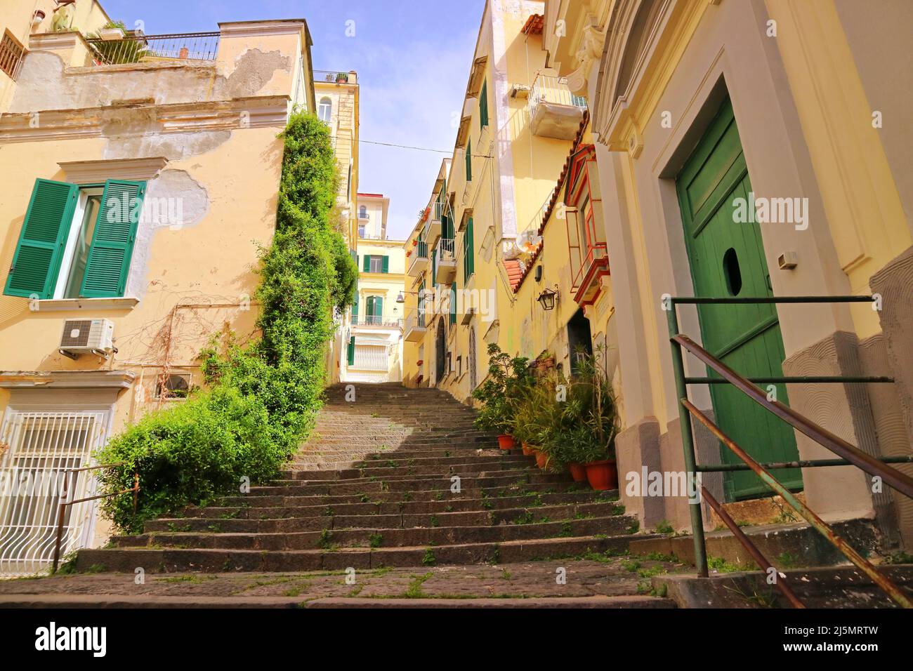 A street between ancient buildings in the historic center of Naples, a ...