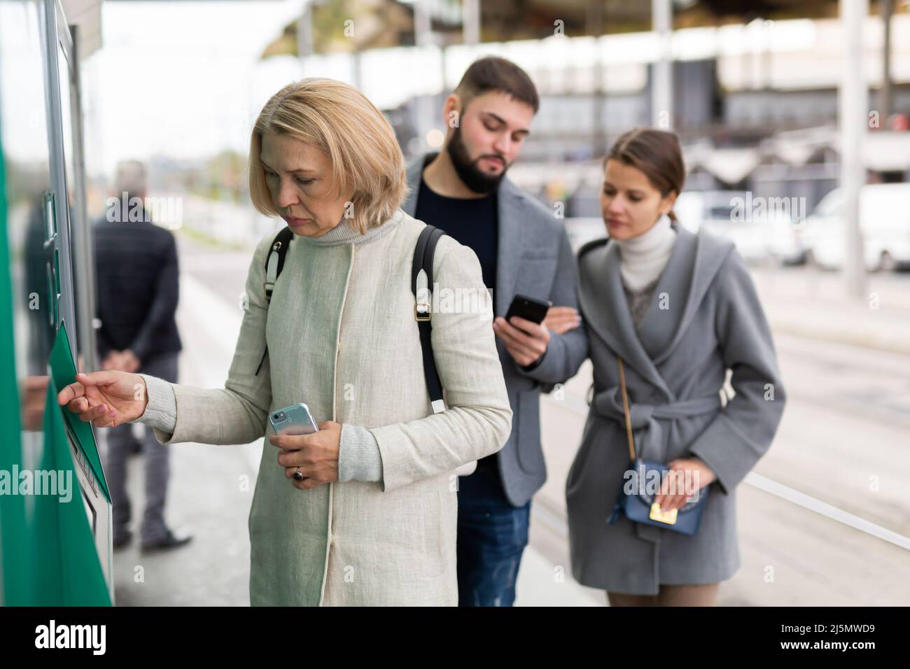 Passengers buying ticket at ticket vending machine Stock Photo - Alamy