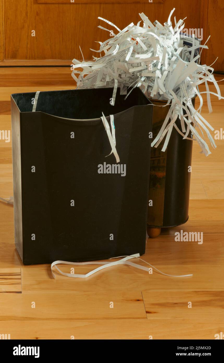 Paper waste shredder basket and wastebasket overflowing with shredded ...