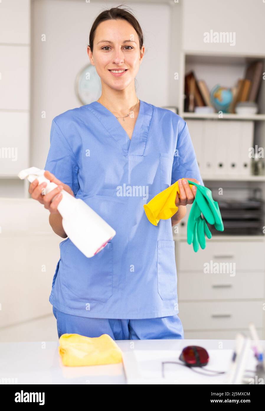 Cleaning lady of cleaning company wipes dust from table in office Stock ...