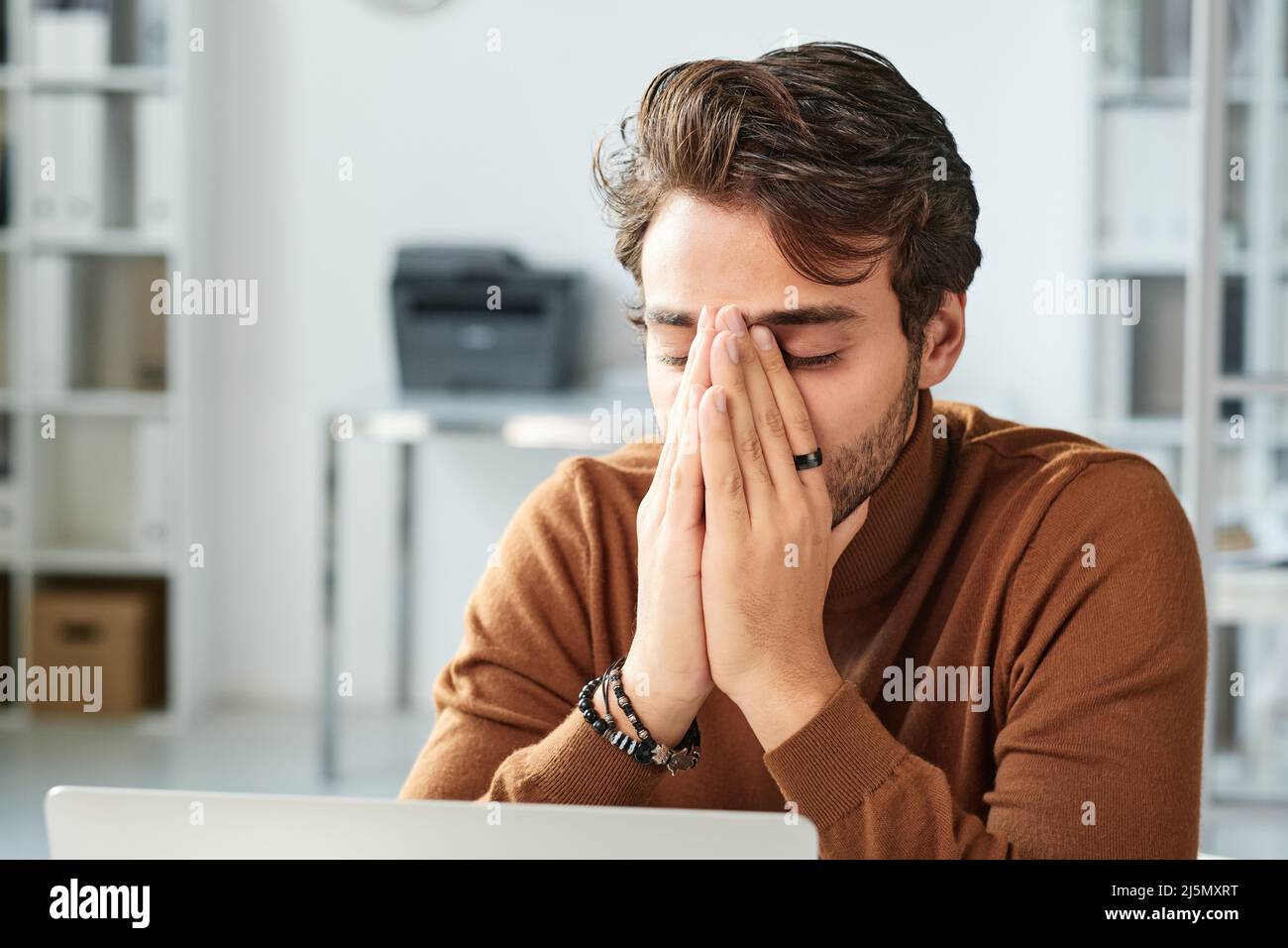 Confused young middle eastern manager with stubble being stressed out ...