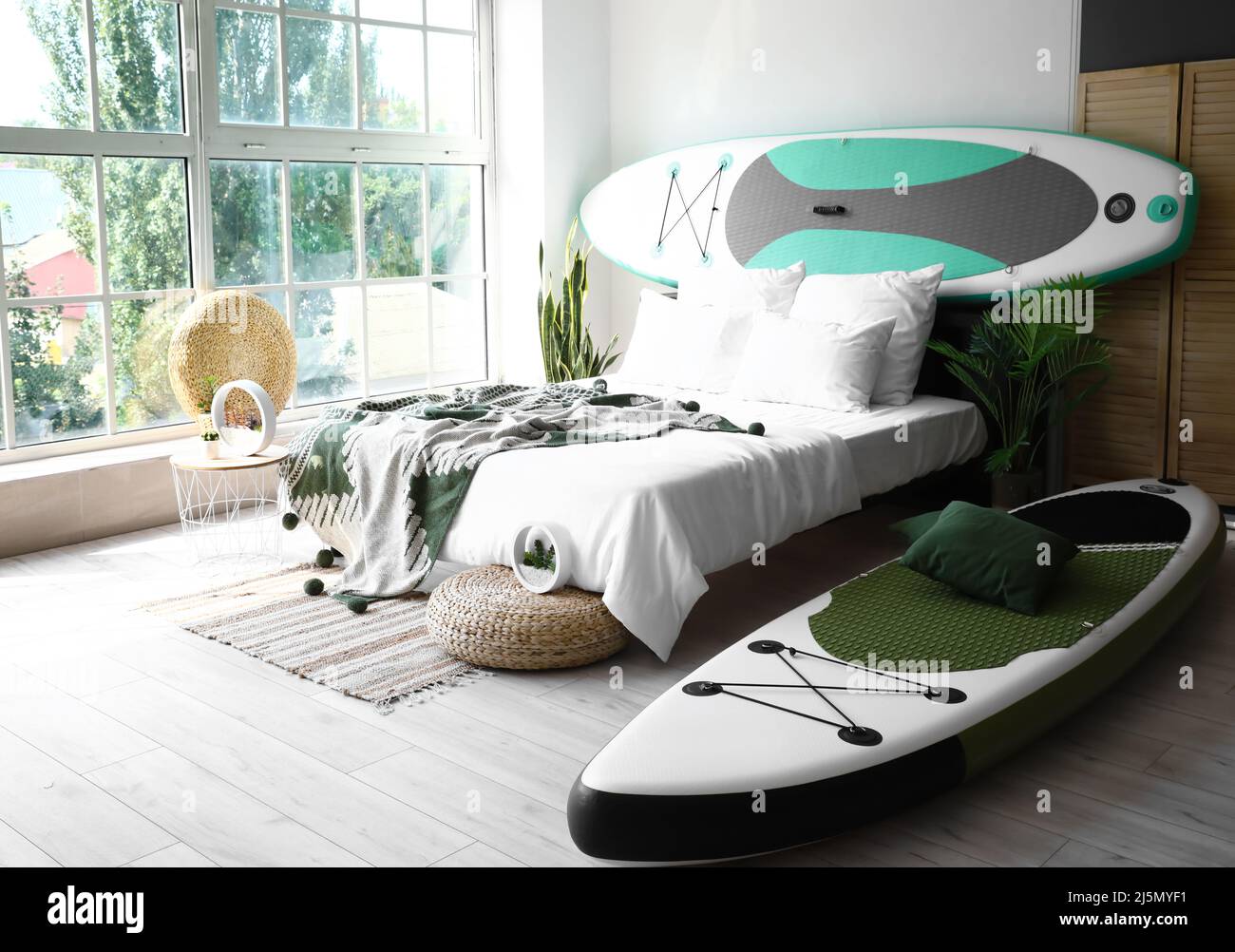 Interior of stylish room with comfortable bed and boards for sup ...