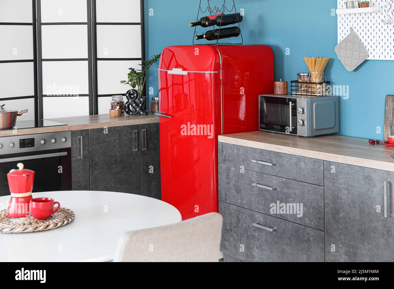 Interior of stylish kitchen with red fridge, microwave oven and ...
