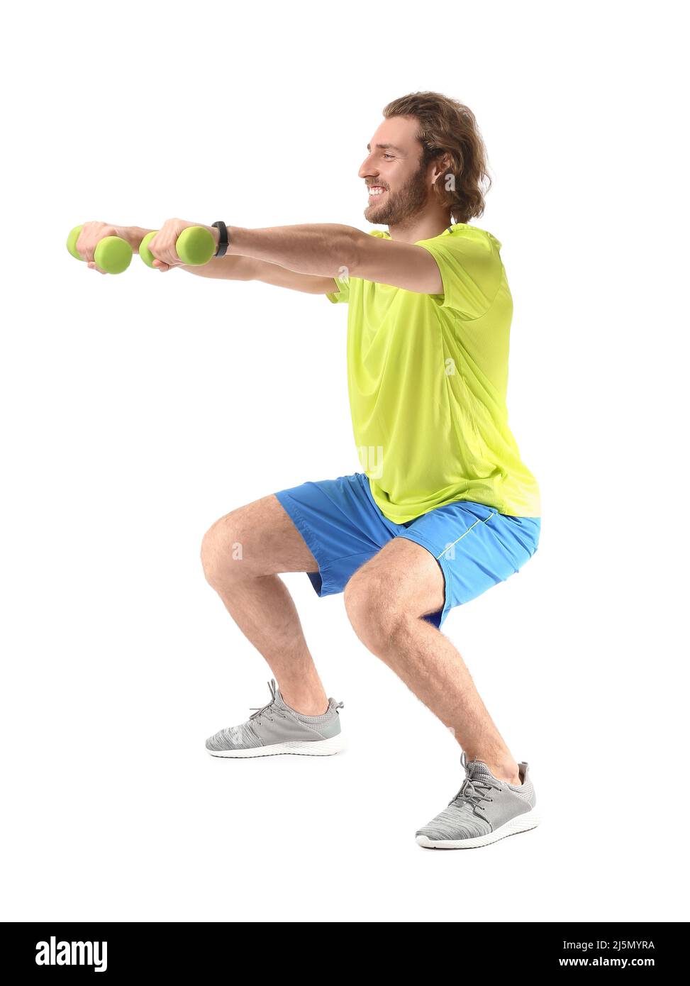 Sporty man with dumbbells doing squats on white background Stock Photo ...