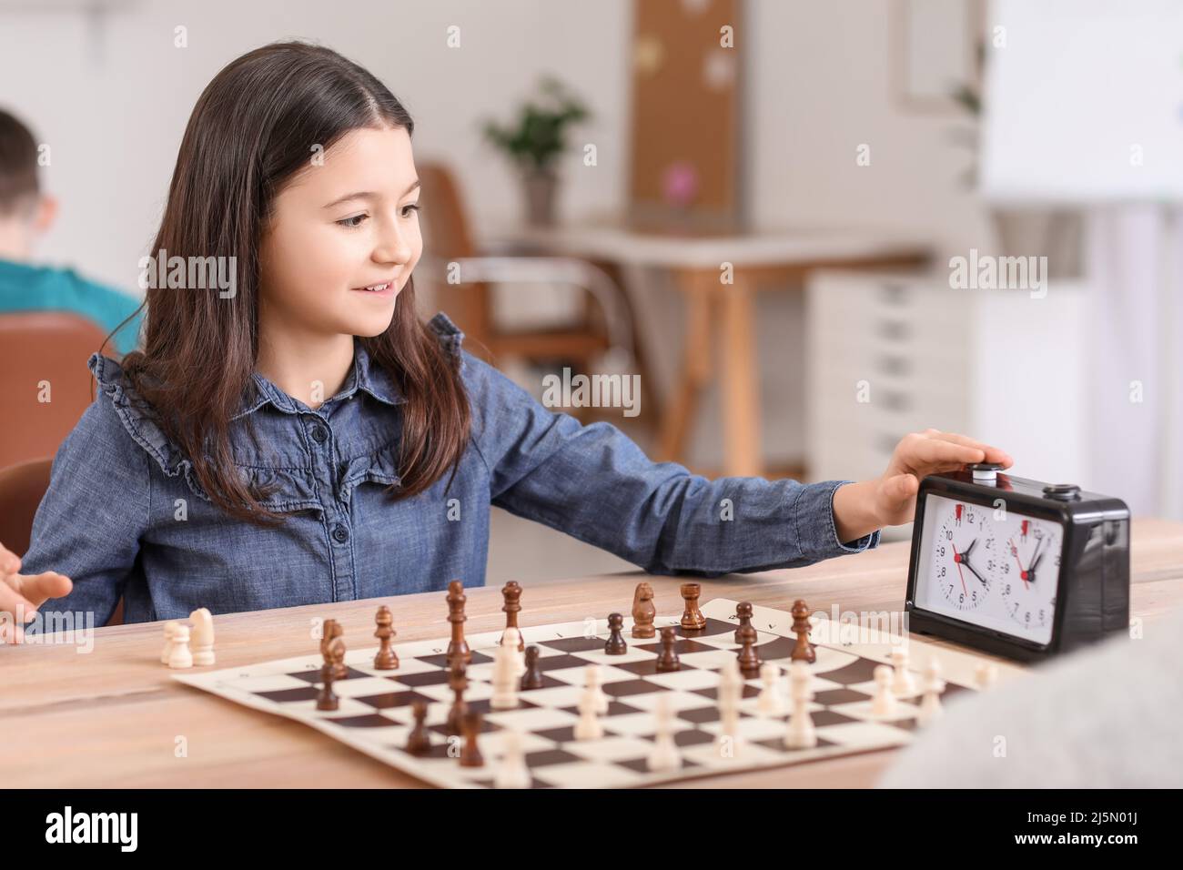 Little girl playing chess during tournament in club Stock Photo - Alamy