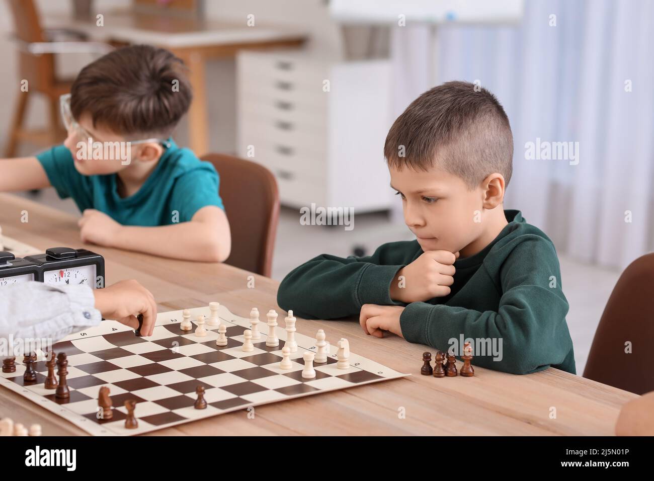 Little children playing chess during tournament in club Stock Photo - Alamy