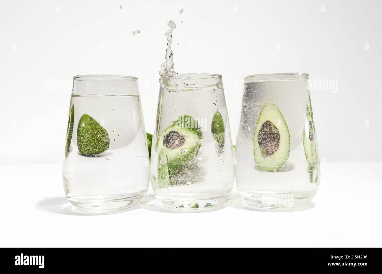 Avocado distorted through liquid and through the glassware full of ...