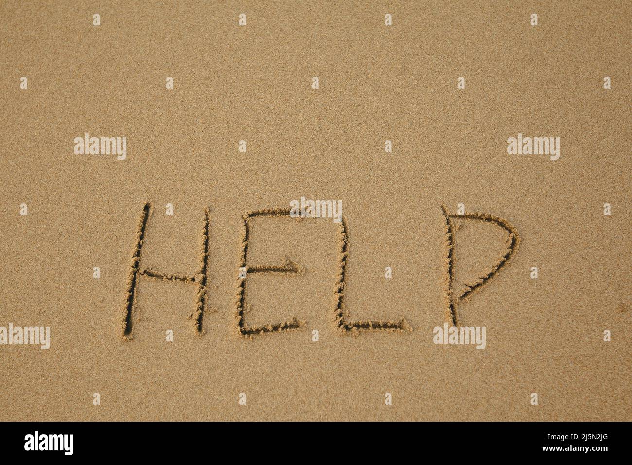 Help - handwritten on the soft beach sand Stock Photo - Alamy