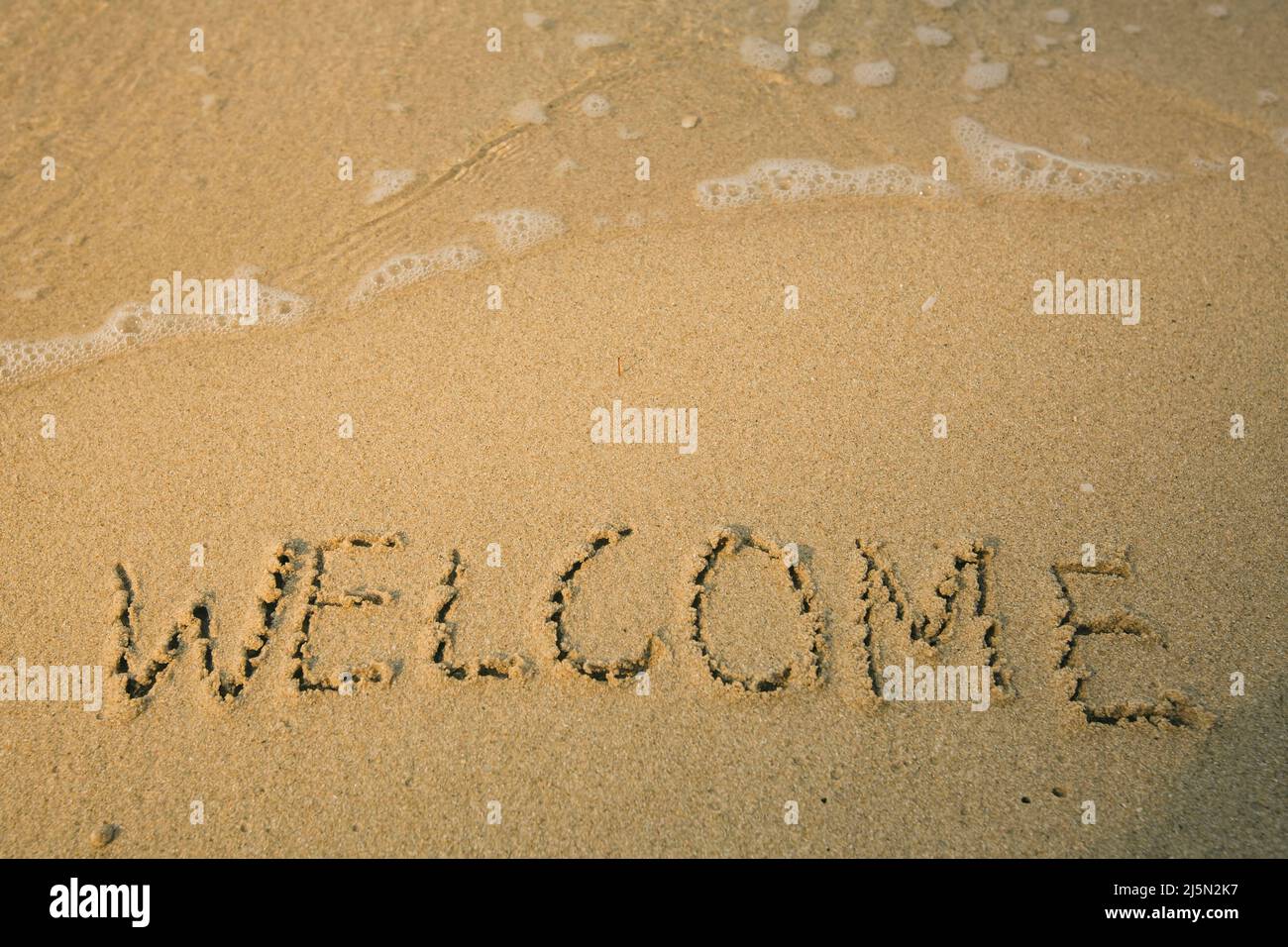 Welcome - handwritten on the soft beach sand Stock Photo - Alamy