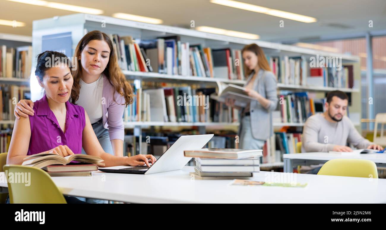 Reading book laptop librarian hi-res stock photography and images - Alamy