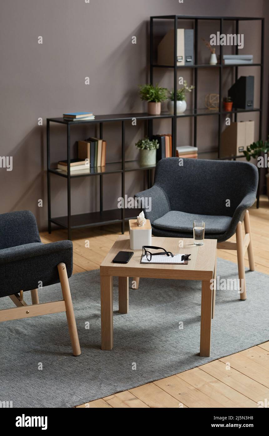 Vertical no people shot of modern psychologist office interior in gray ...