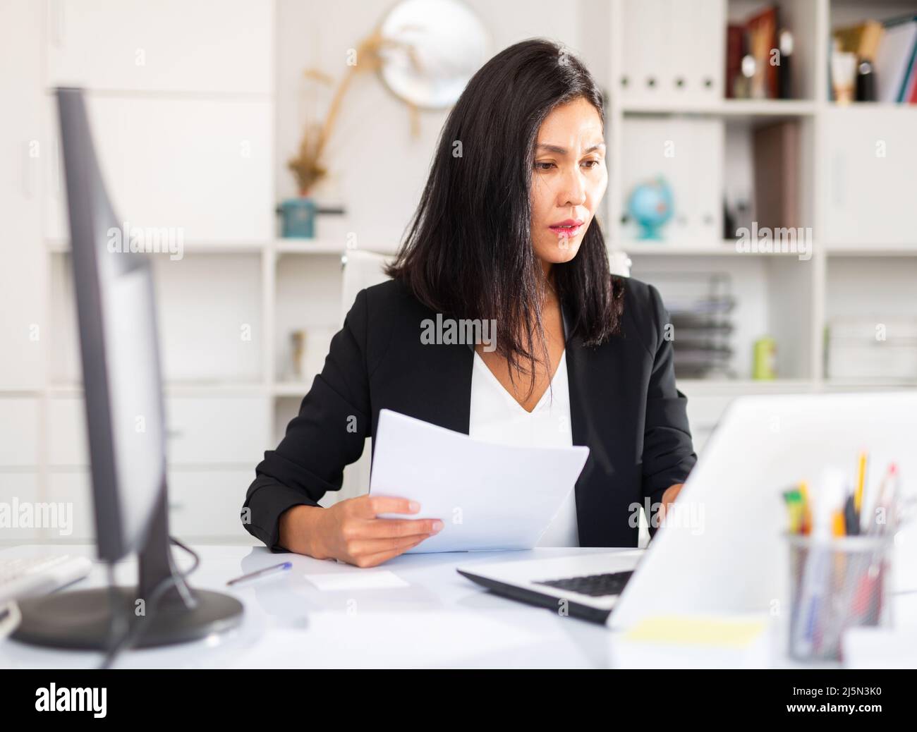 Worried young woman manager working with documents Stock Photo - Alamy