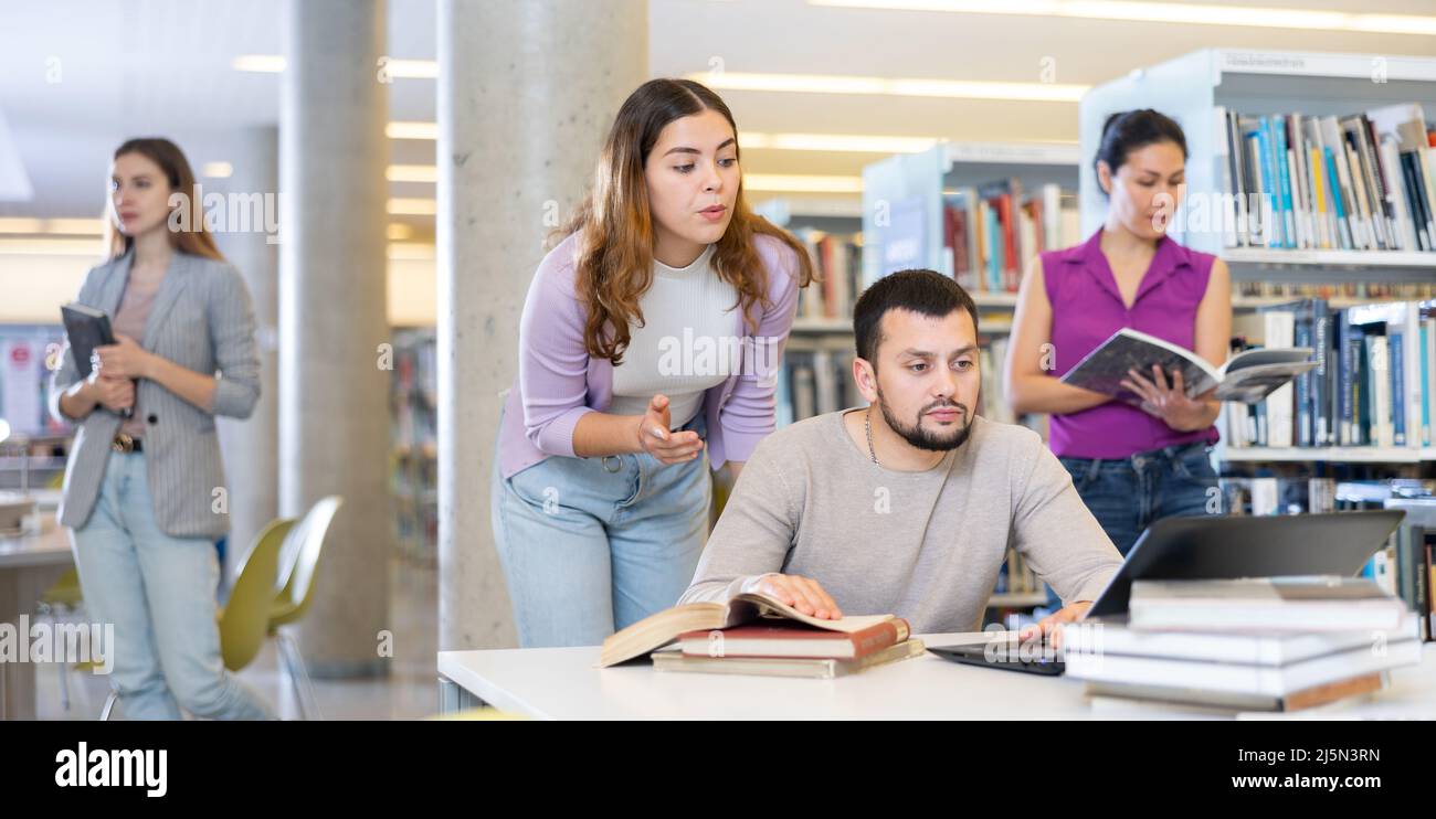 Woman and man studying together at library Stock Photo - Alamy