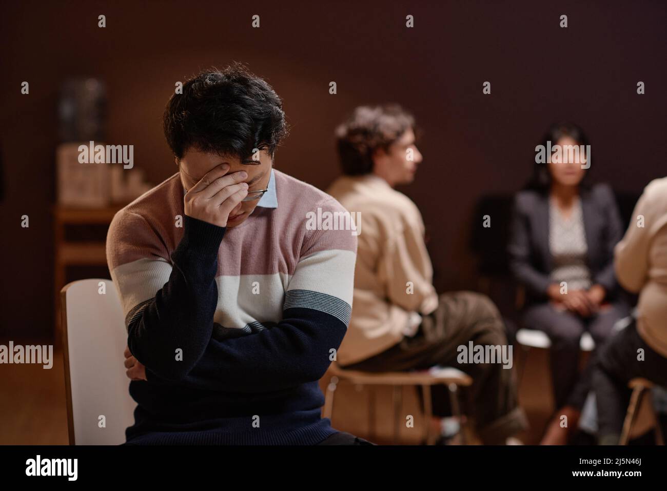 Horizontal medium portrait of young adult Asian man suffering ...