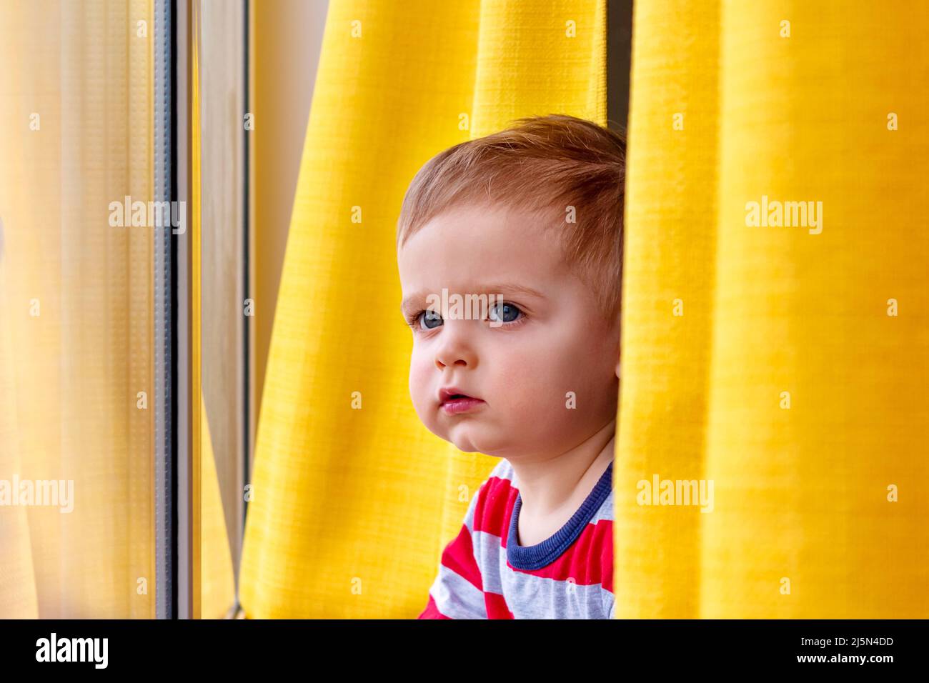 Little boy looking out the window. Close-up Stock Photo - Alamy