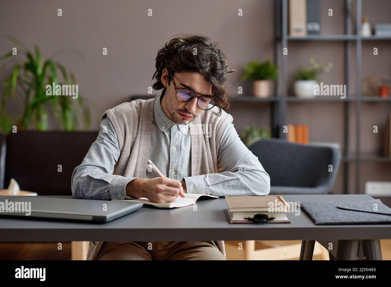 Psychologist sitting desk writing in hi-res stock photography and ...