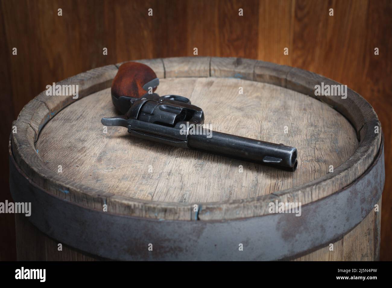 Old west revolver 45 cal on vintge wooden barrel Stock Photo - Alamy