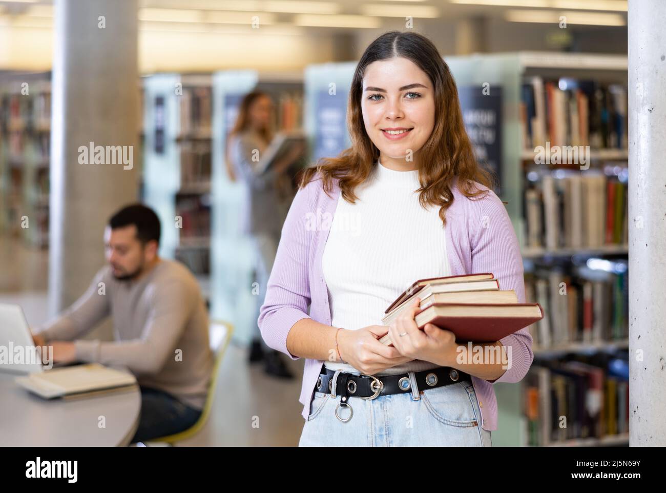 Portrait of a young woman in the library with textbooks Stock Photo - Alamy