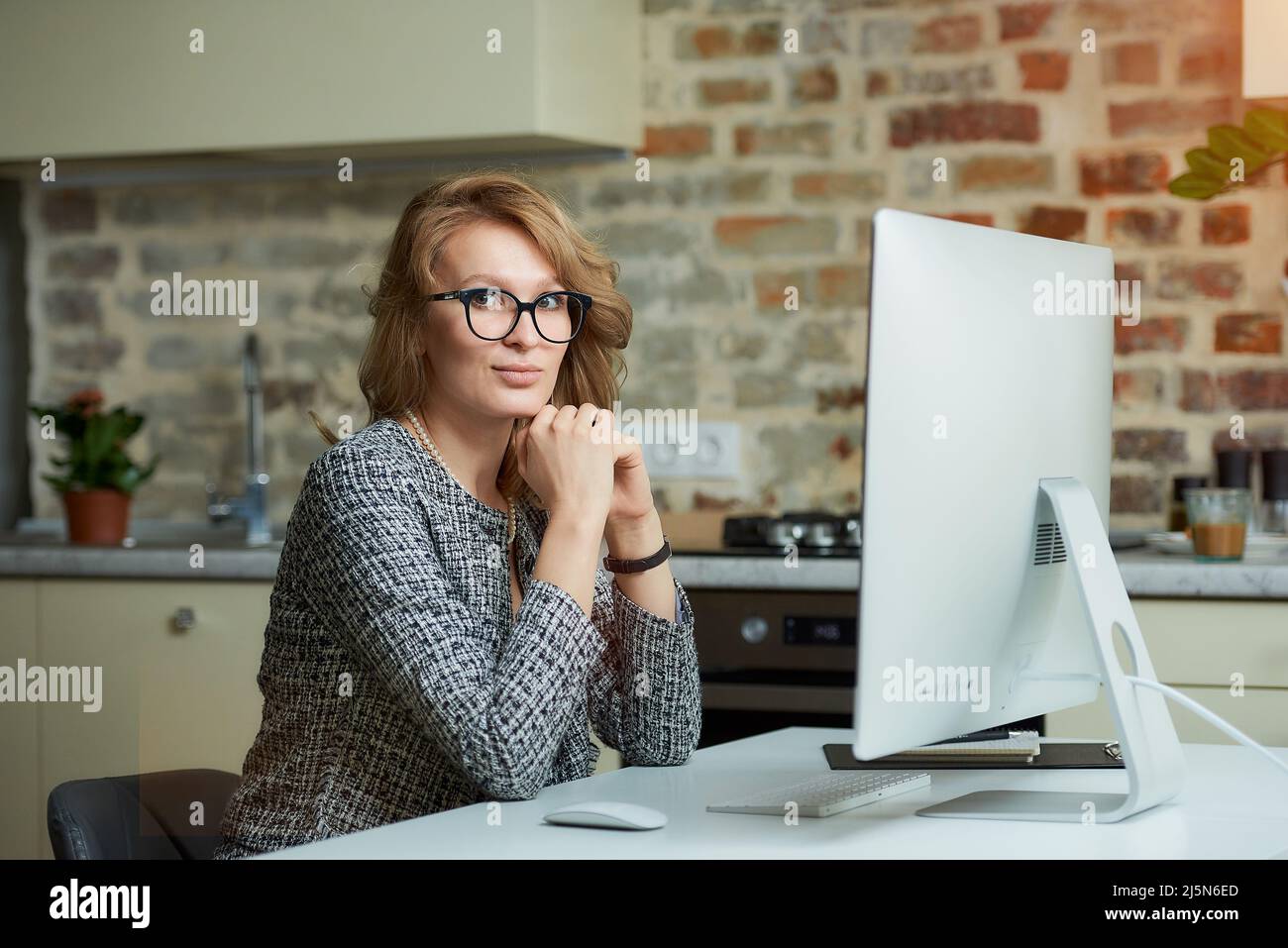 A woman working on a desktop computer with her employees at a video ...