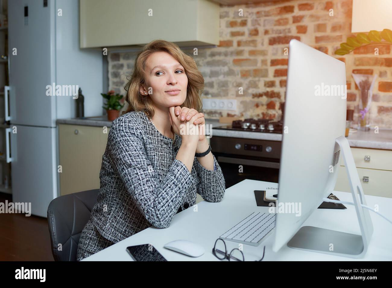 A woman working on a desktop computer with her employees at a video ...