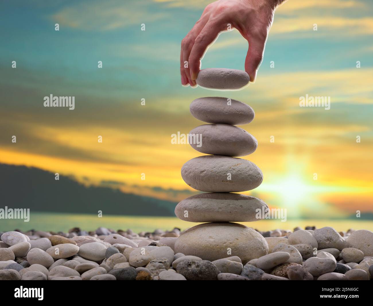 The man's hand is putting gravel on the stone tower. Personal ...