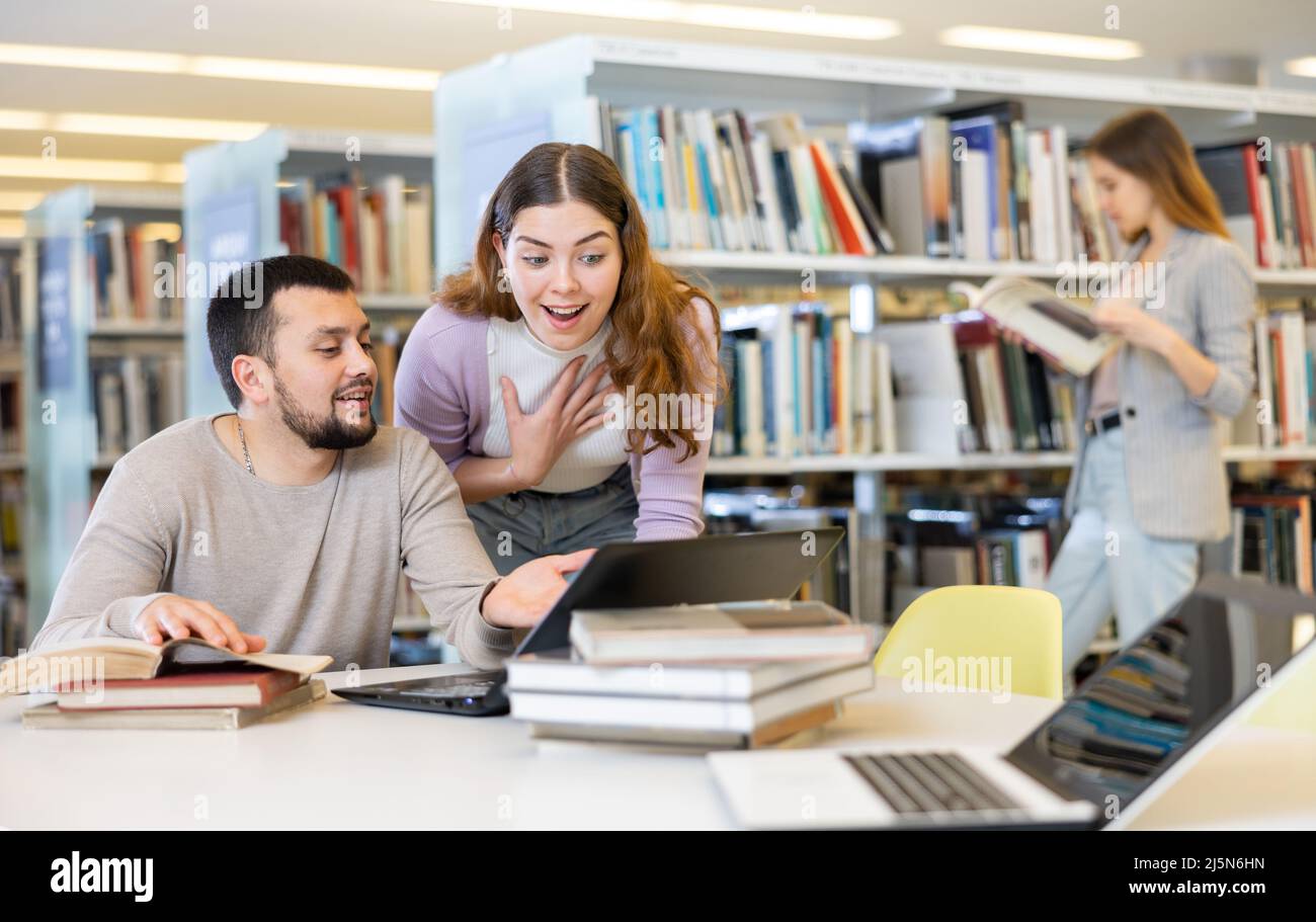Positive adults communicating while preparing to exam in library Stock ...