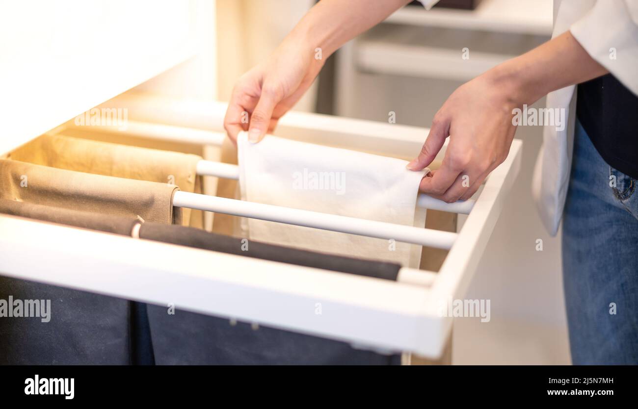 The female hand arranges clothes in a neat and orderly in closet in the ...