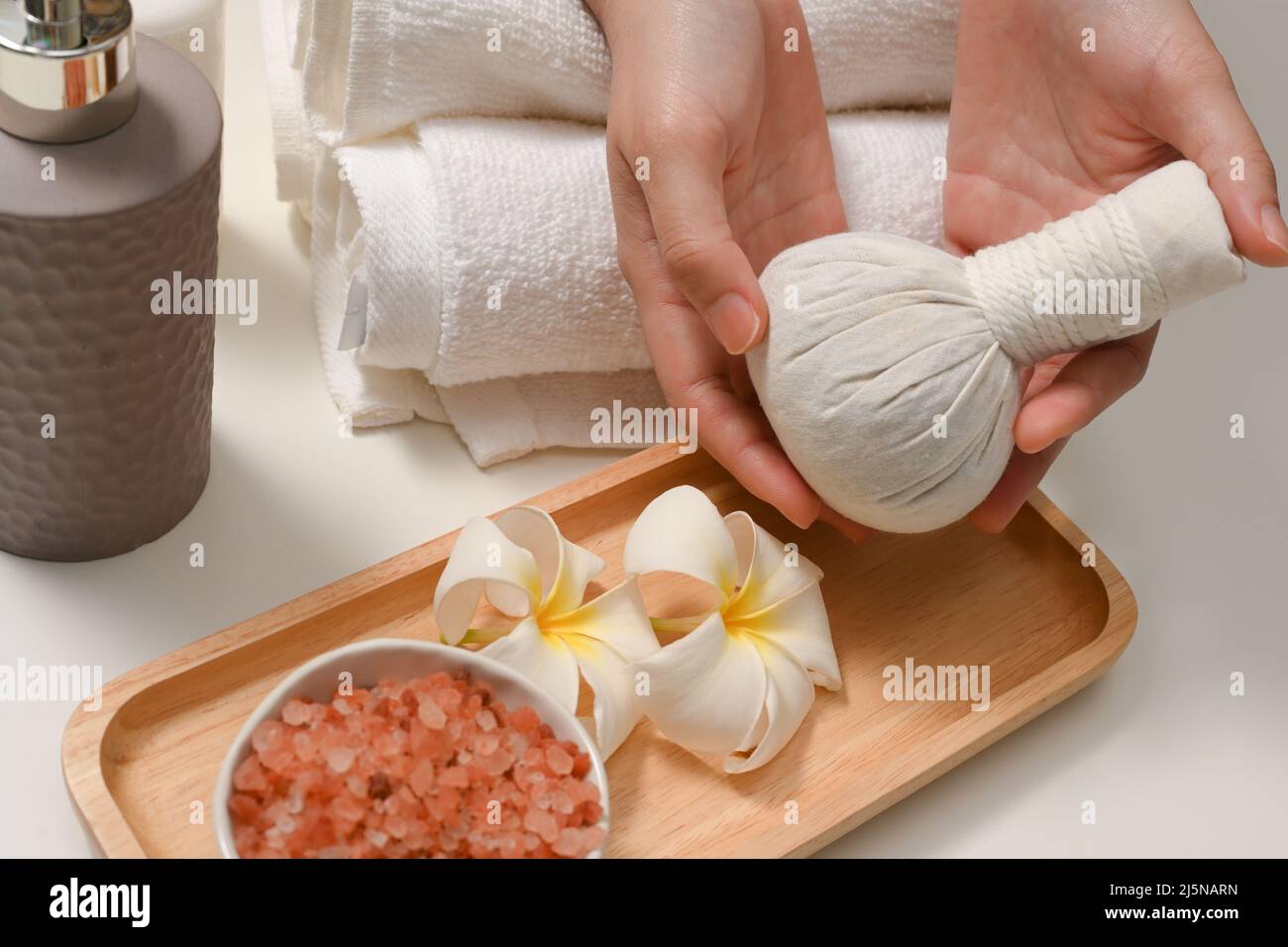 Close-up, Female hands holding a massage stamp or spa herbal ball or ...