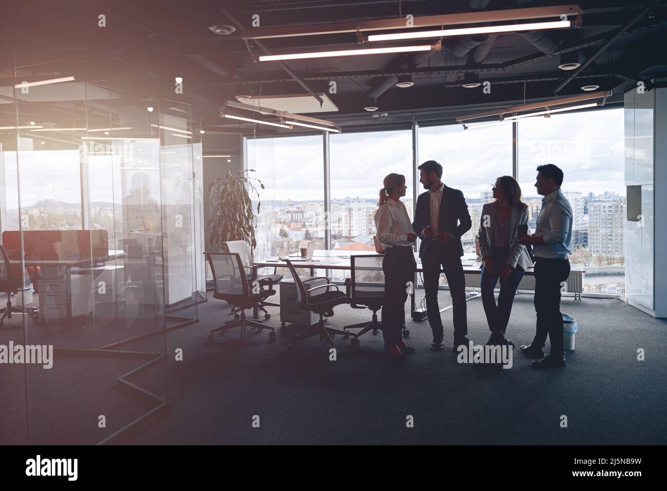 Business team standing against panoramic windows in modern office Stock ...