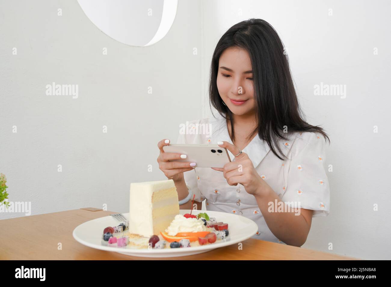 Beautiful Asian millennial woman taking a yummy desserts photo with her ...