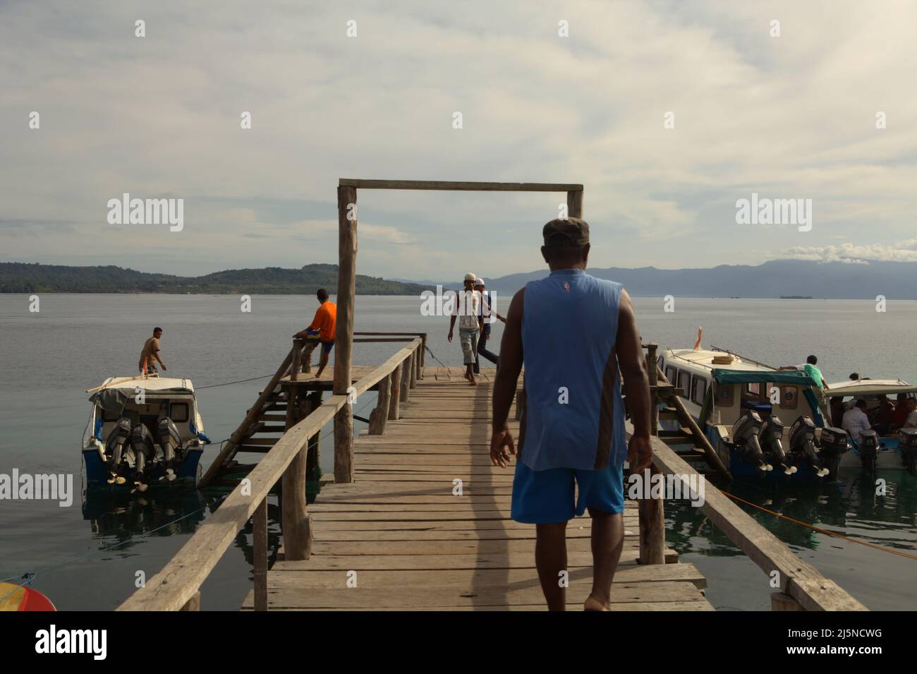 Activities of people on a wooden jetty for chartered speedboats in ...
