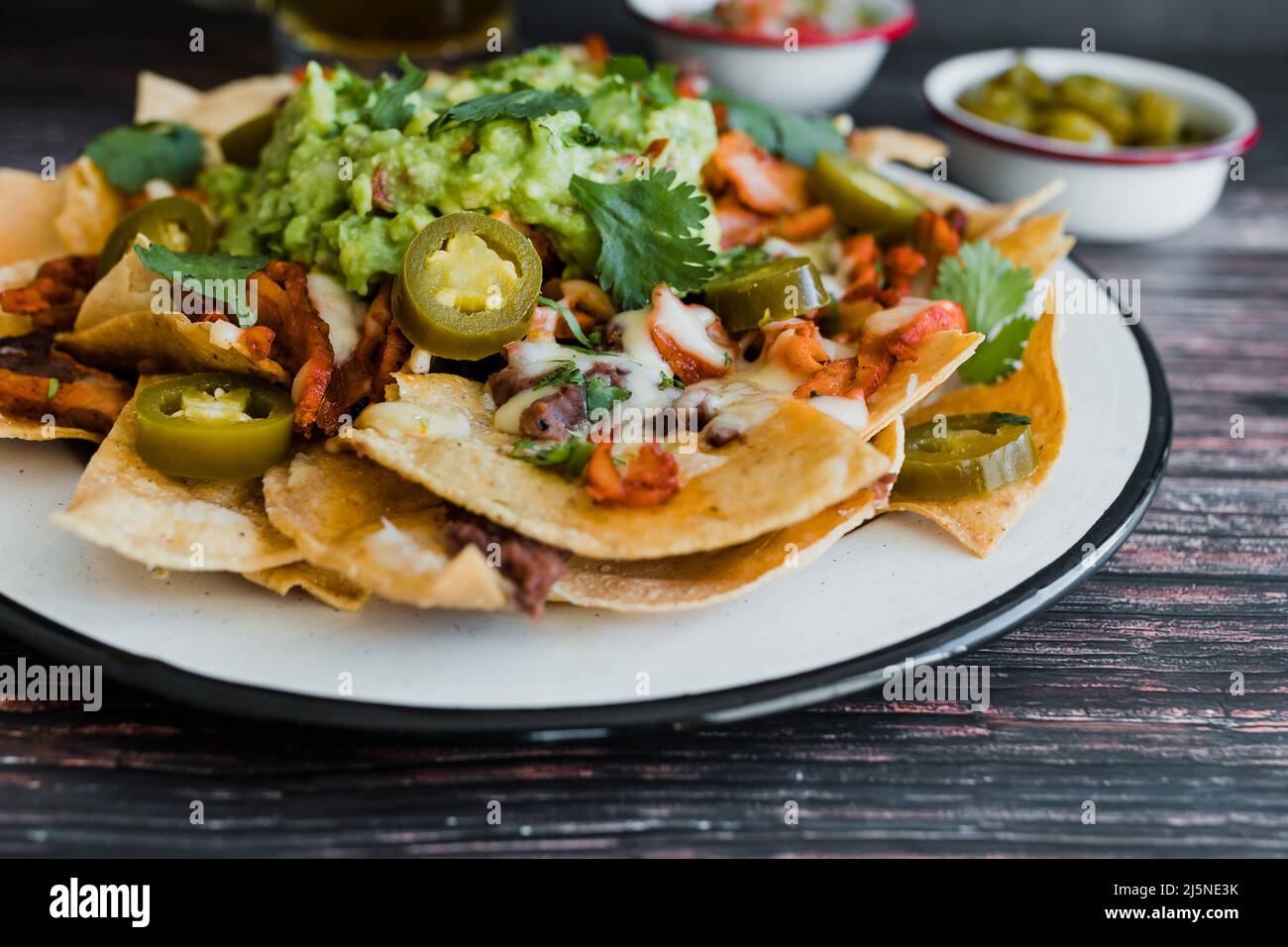 Mexican nachos chips with american cheese and avocado, traditional food ...