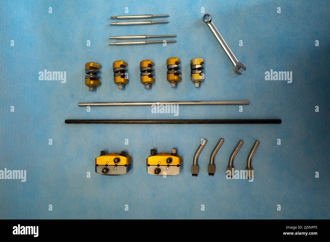 a single parts of a surgical hand fixator lie on a blue surgical cloth ...