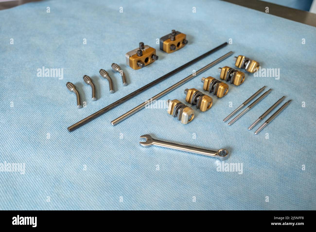 a single parts of a surgical hand fixator lie on a blue surgical cloth ...