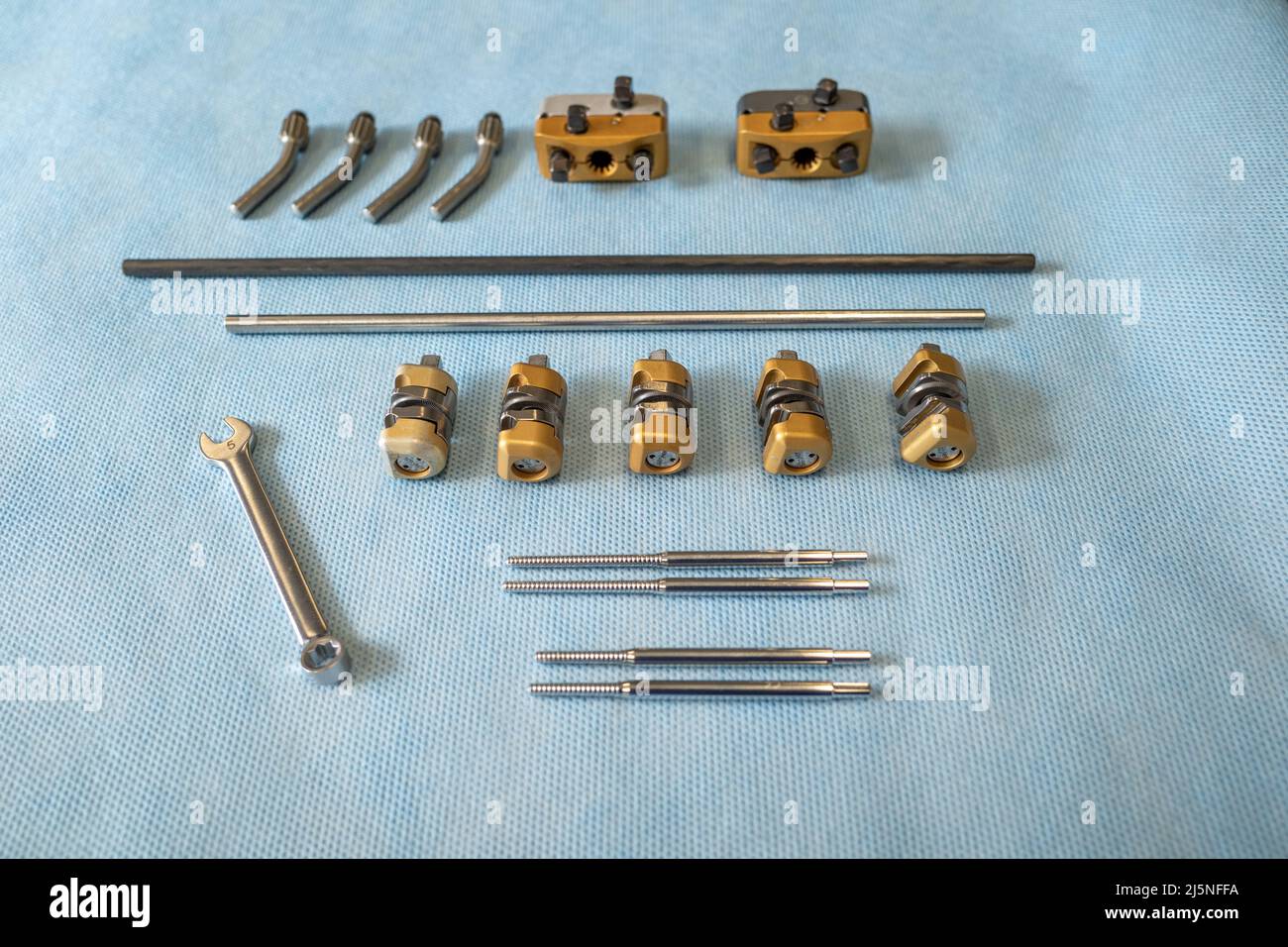 a single parts of a surgical hand fixator lie on a blue surgical cloth ...