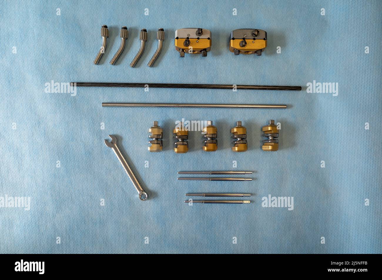 a single parts of a surgical hand fixator lie on a blue surgical cloth ...