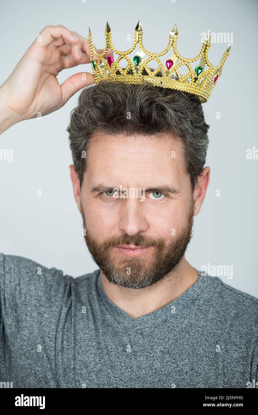 Young man with golden crown of king over gray background. Handsome man ...